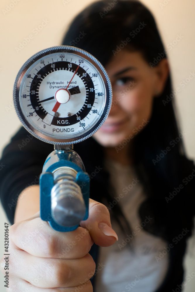 Girl using grip strength dynamometer for testing hand grip strength ...