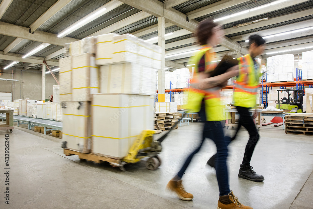 Workers moving cargoes in distribution warehouse Stock Photo | Adobe Stock