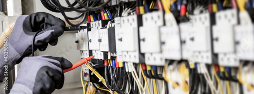Electrician engineer tests electrical installations and wires on relay ...