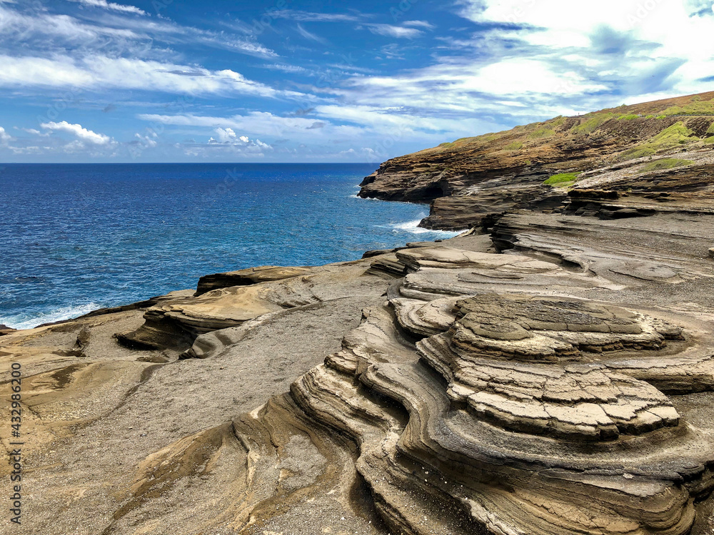 Rocky cliffs and Pacific Ocean wake surf along shoreline of coast of ...