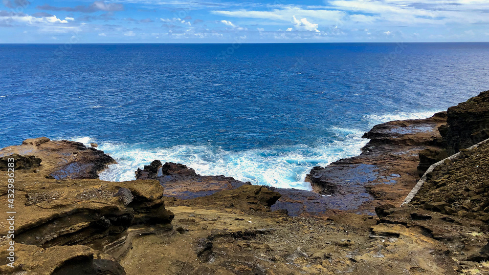 Rocky cliffs and Pacific Ocean wake surf along shoreline of coast of ...