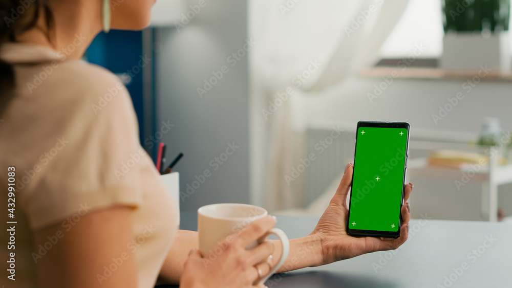 Caucasian female having online videocall using mock up green screen ...