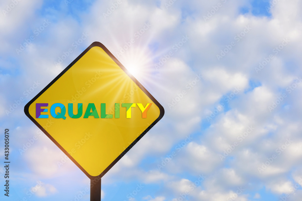 Colorful rainbow equality word written on yellow sign on beautiful blue ...