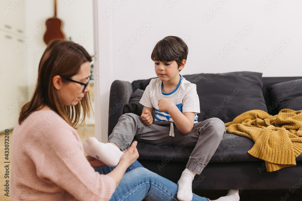 mother helps her son to puts on socks Stock Photo | Adobe Stock mother helps her son to puts on socks Stock Photo | Adobe Stock