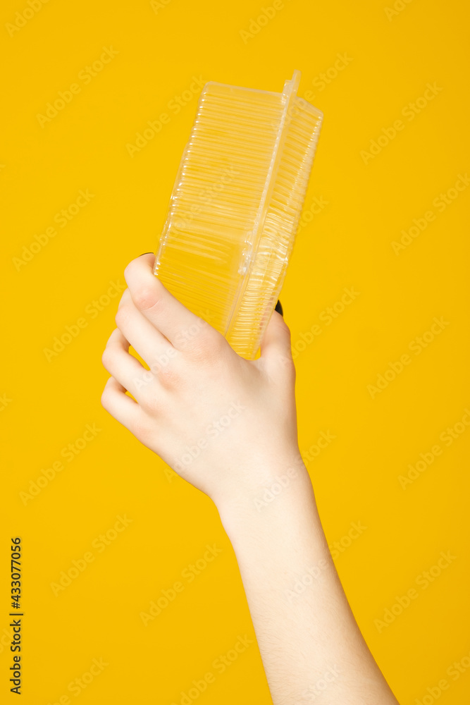 We are against plastic garbage. Hand clutches an disposable plastic box ...