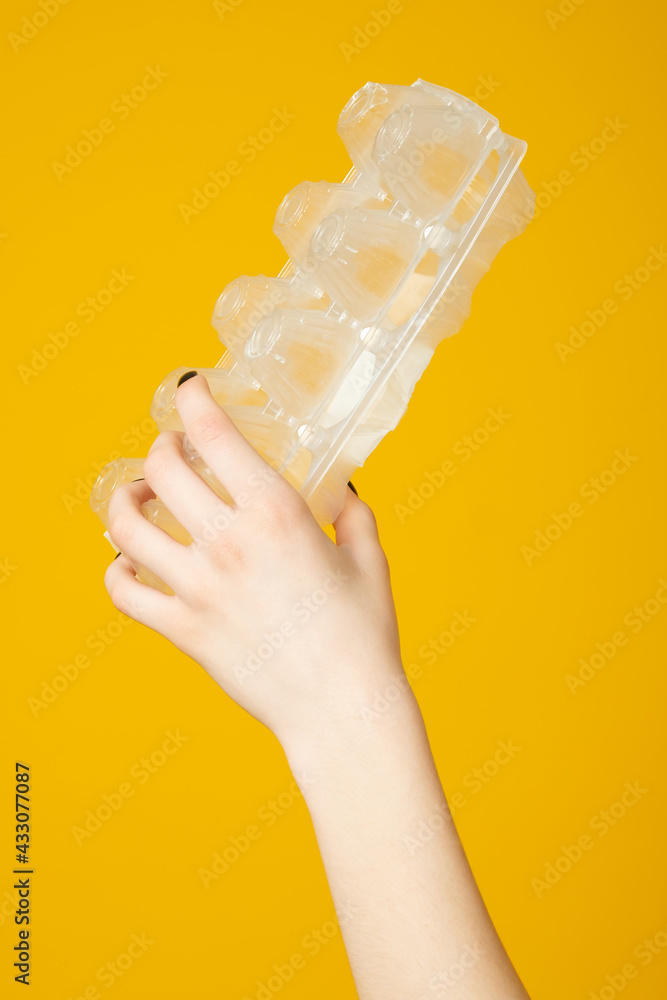 We are against plastic garbage. Hand clutches an disposable plastic box ...