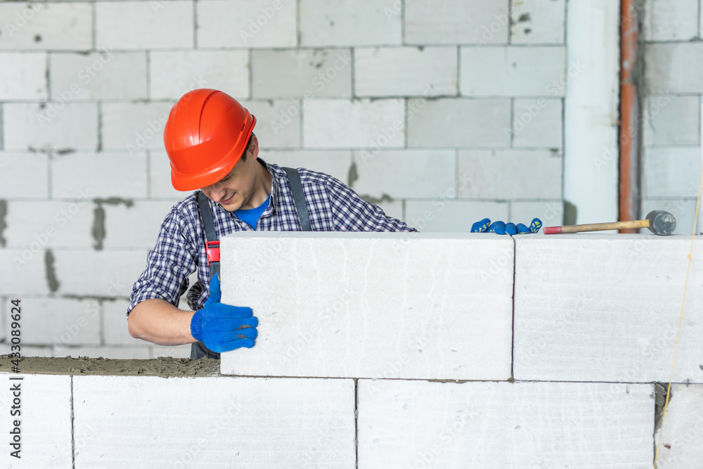 Bricklayer builder working with autoclaved aerated concrete blocks ...