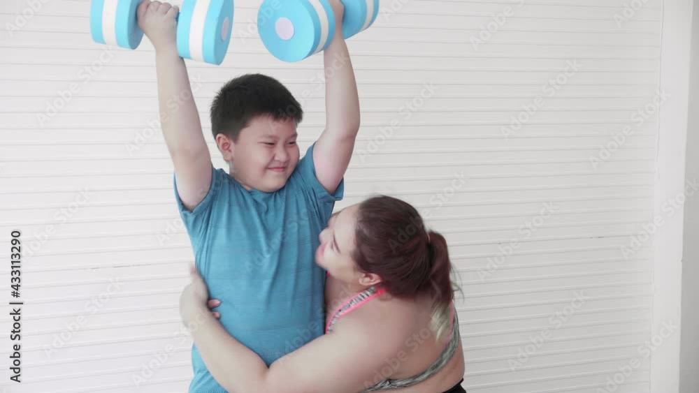 Asian family son fat exercise with dumbbell and mother cheer at home ...