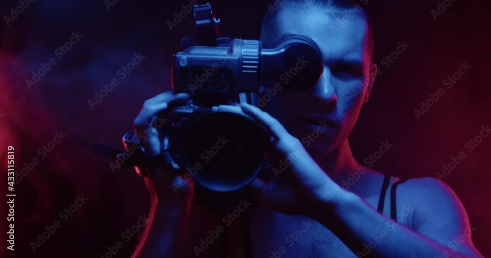 Vídeo do Stock: A stylish male hipster cameraman from the 80s with a ...