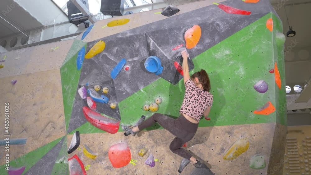 CLOSE UP: Fit Caucasian female athlete trains at an indoor climbing ...
