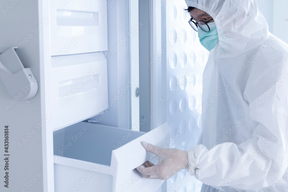A laboratory technician opening a low temperature freezer. Stock Photo ...
