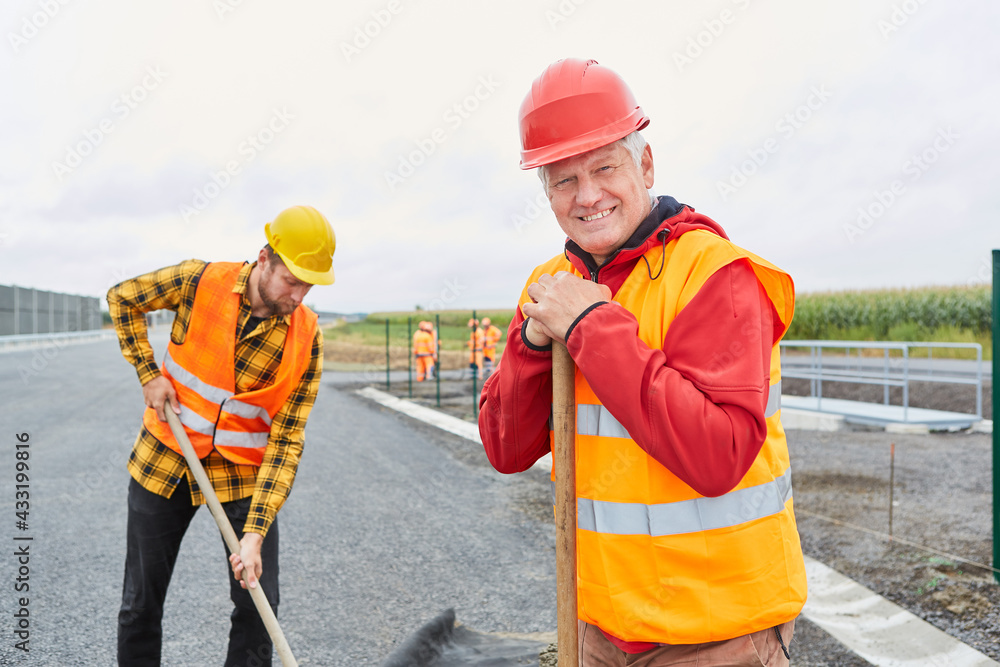 Construction workers building or upgrading a road Stock Photo | Adobe Stock