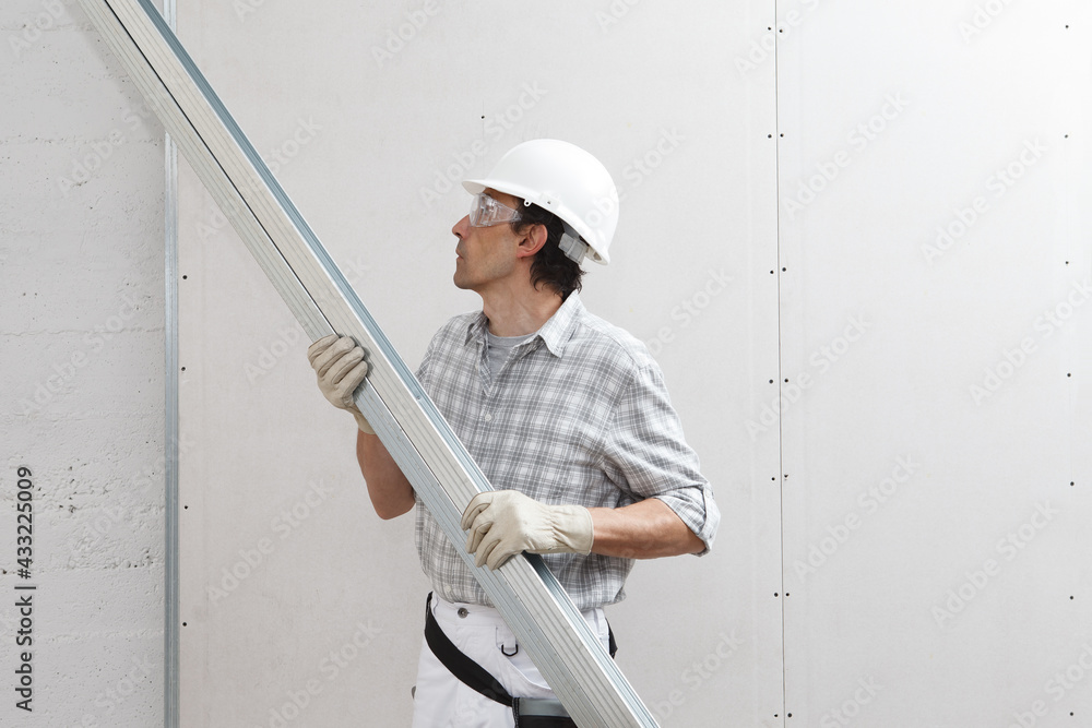 man worker with drywall metal profiles for installing plasterboard ...