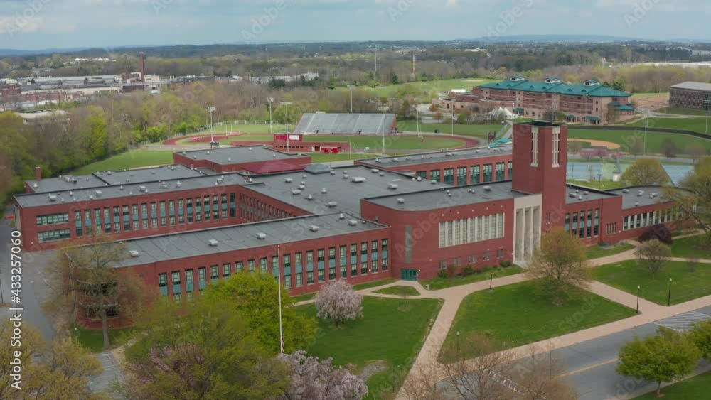 Rising aerial reveals large red brick academic school university ...