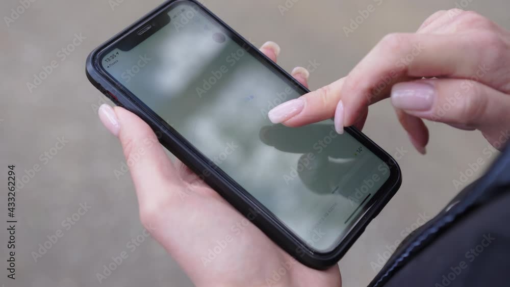 Tourist looks maps mobile phone. Use your fingers zoom out location ...