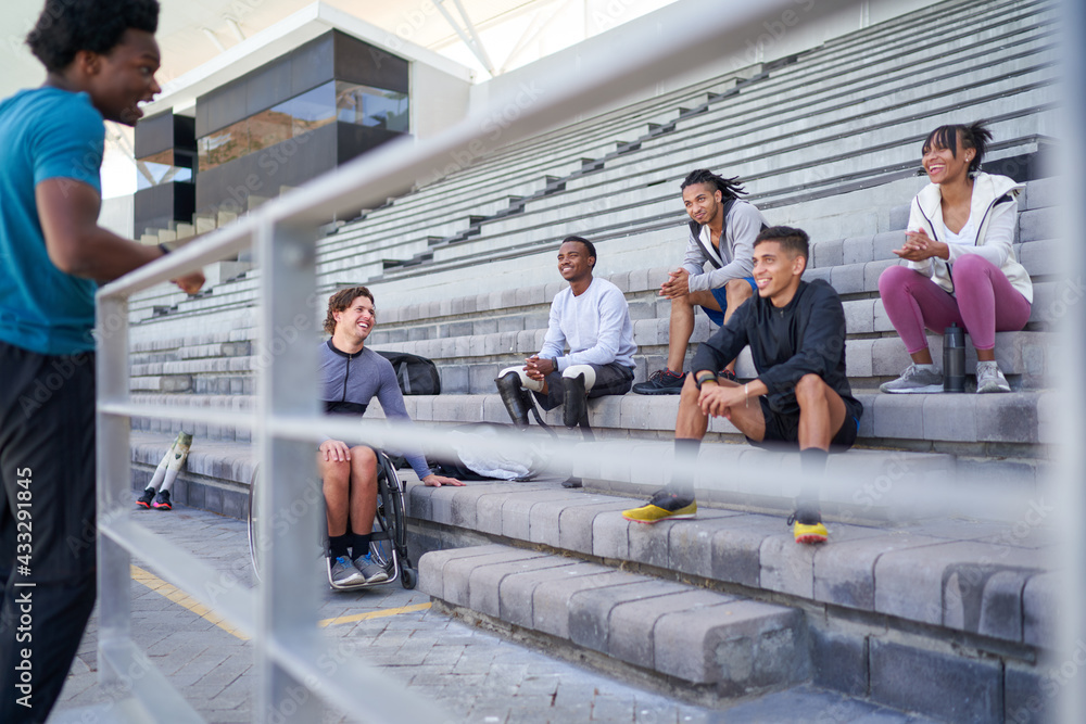 Athlete friends talking in stadium bleachers Stock Photo | Adobe Stock