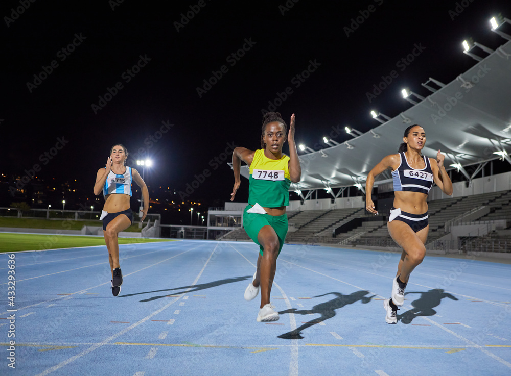 Female track and field athlete running in competition on track Stock ...