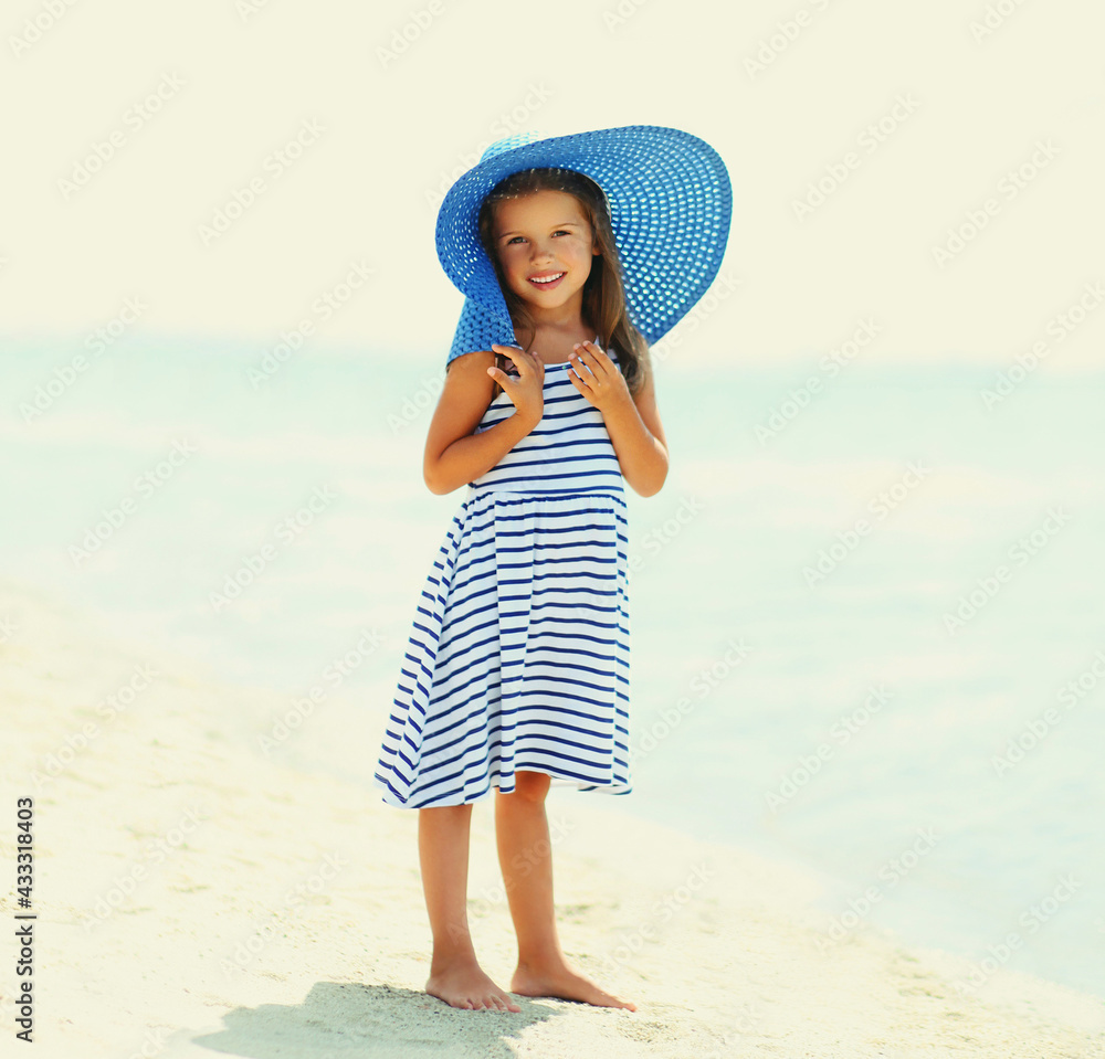 Summer portrait beautiful little girl child wearing a striped dress and ...