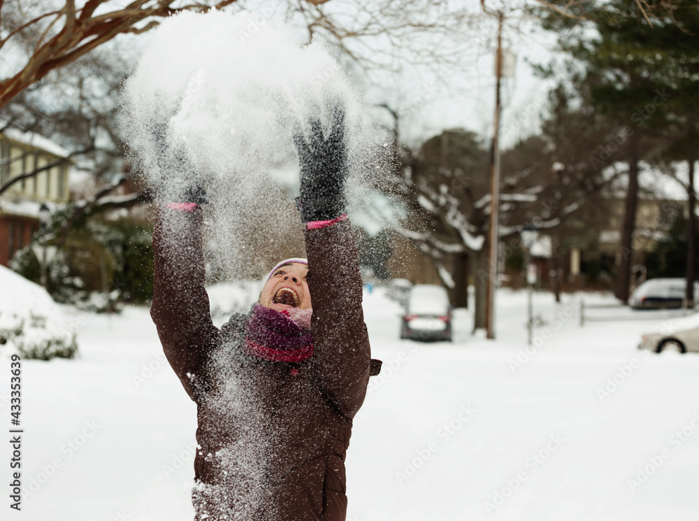 Teenage girl throwing powdered snow mid air Stock Photo | Adobe Stock