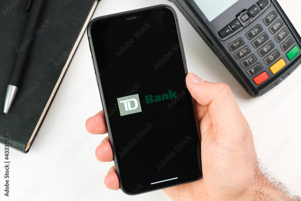 TD bank logo on the black smartphone screen in mans hand on the ...