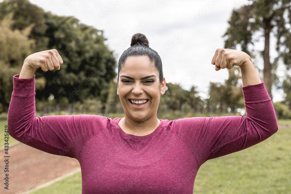 Plus size body woman at city park posing showing biceps muscles - Focus ...