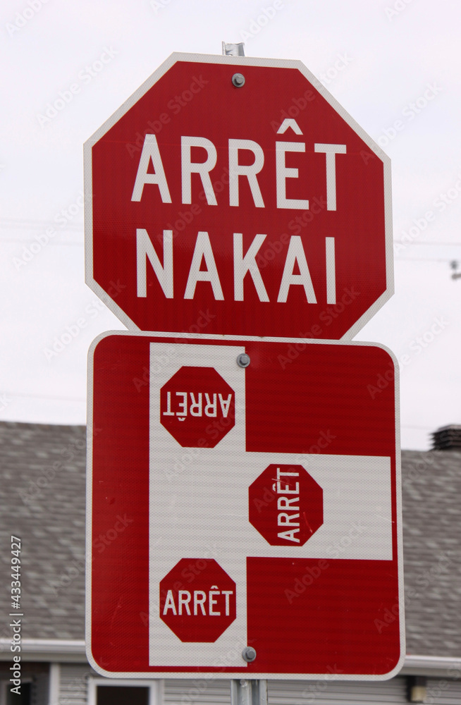 red and white stop sign with stop text in French and local native ...