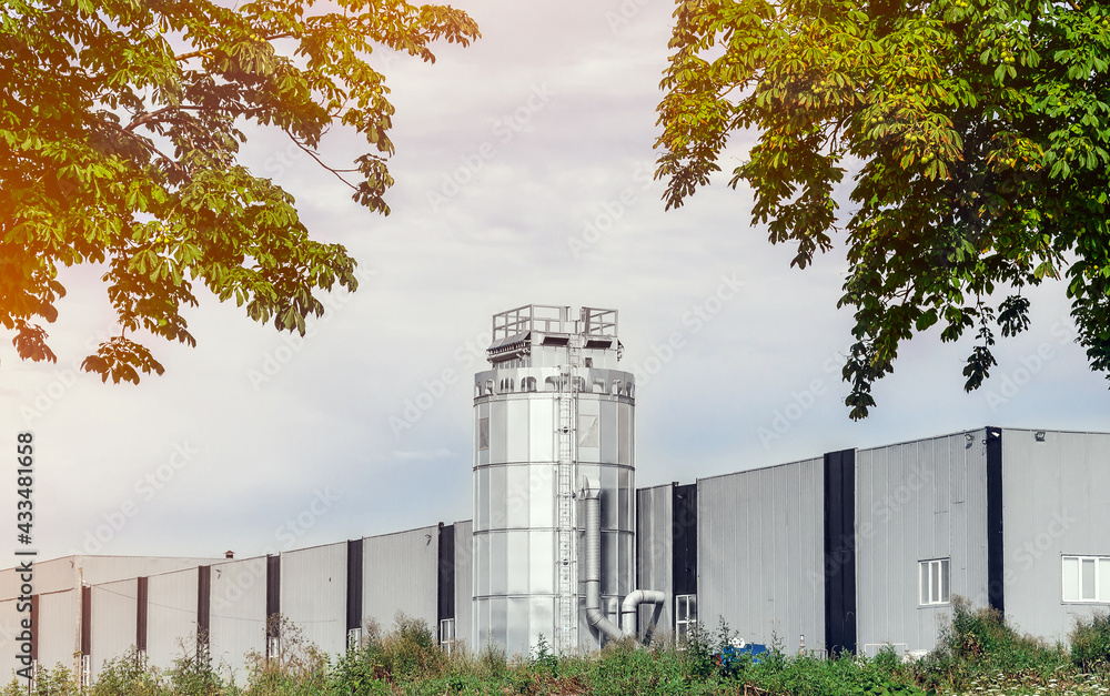 Shiny metal tower pipe at plant for waste treatment. Environmental ...