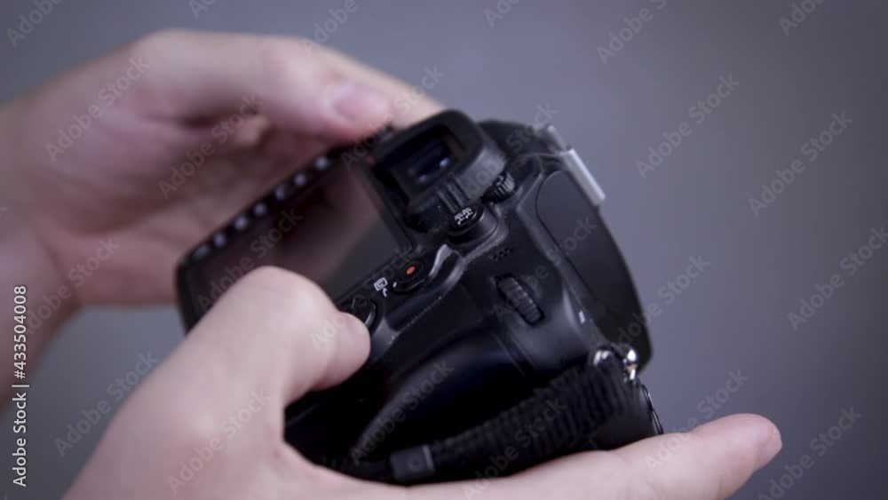 A photographer adjusts the camera. The fingers of the photographer are ...