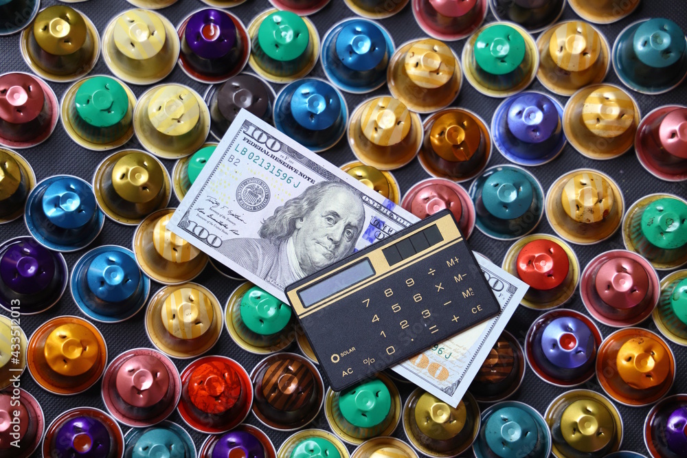 Calculators and one hundred dollar bill lie on a field of empty ...