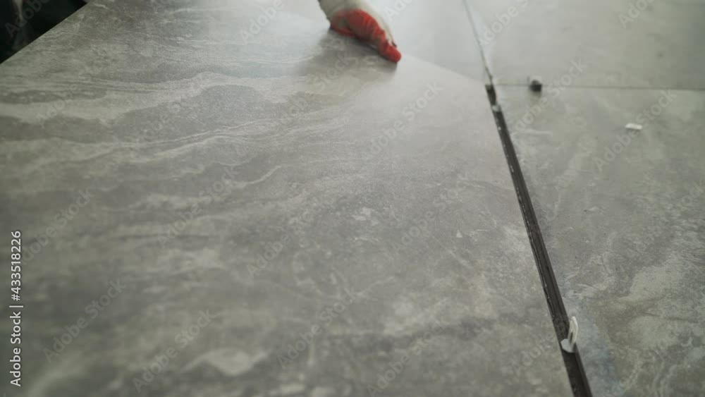 Adhesive solution for gluing ceramic floor tiles. Professional worker ...