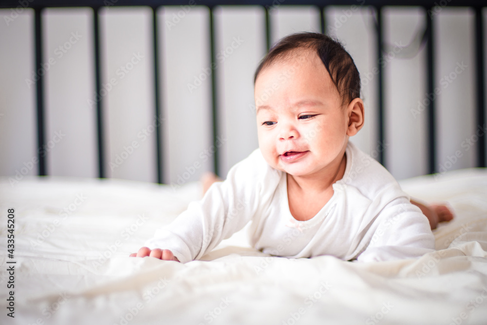 Infants are looking forward in an upside-down position on a white bed ...