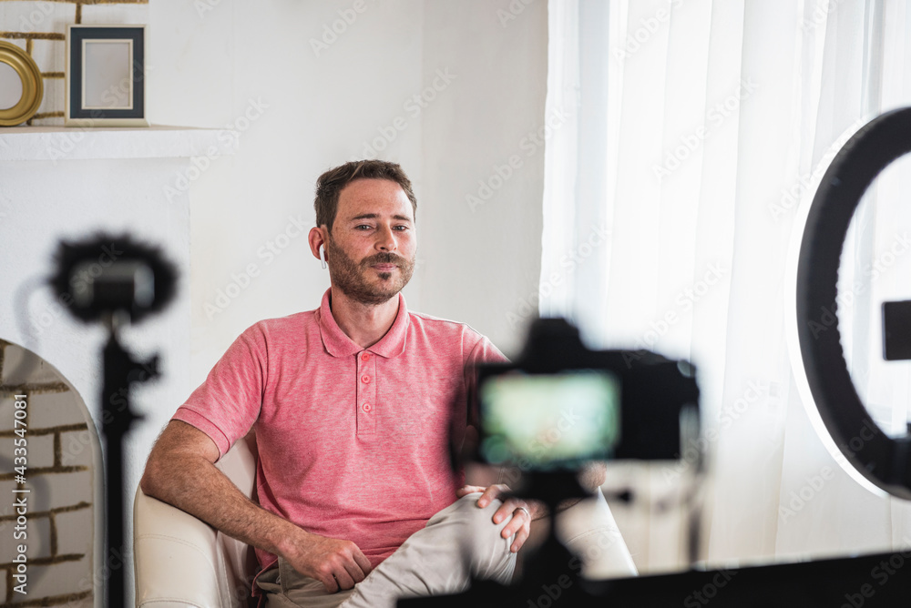 detrás de cámara de un hombre siendo entrevistado con luces y ...