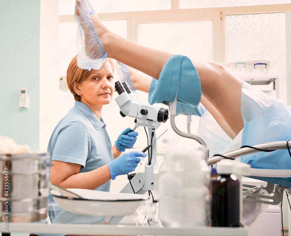 Female patient in shoe covers laying in gynecological chair while ...