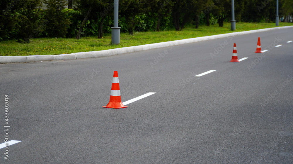 Macro shot of road traffic cones with orange and white stripes standing ...