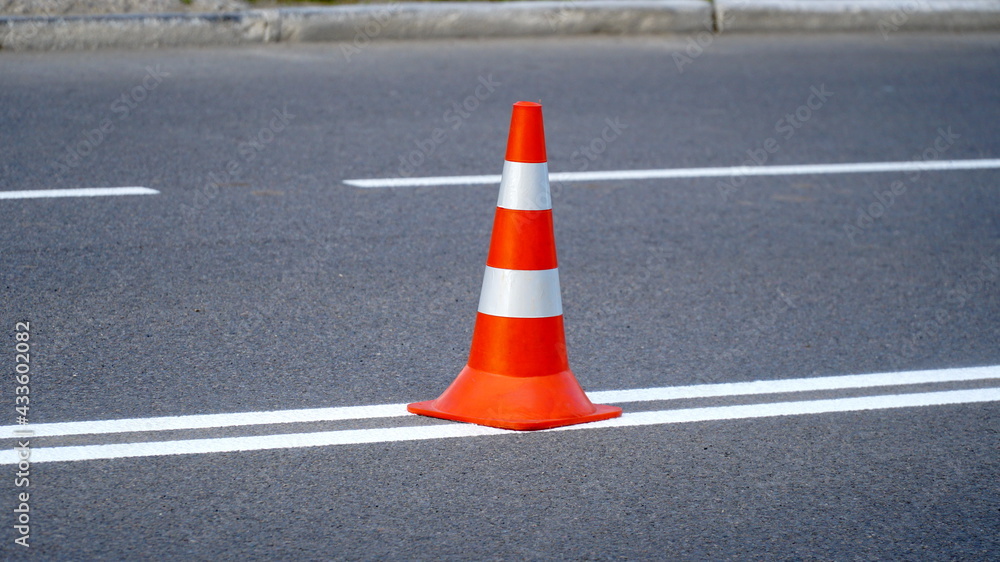 Macro shot of road traffic cones with orange and white stripes standing ...
