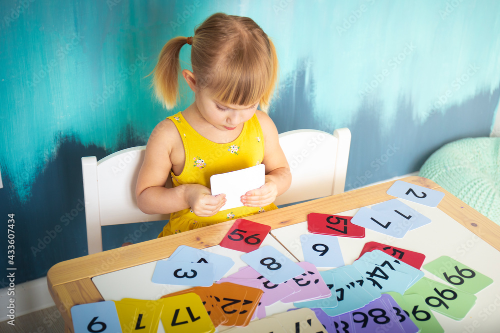 Little caucasian girl studying numbers and math in the classroom ...