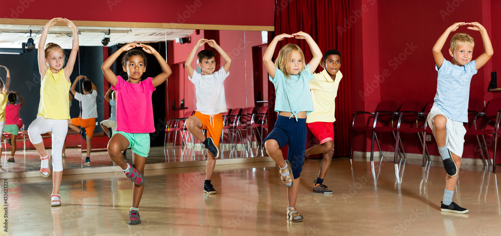 Group of positive childrens trying balance movements of ballet at a ...