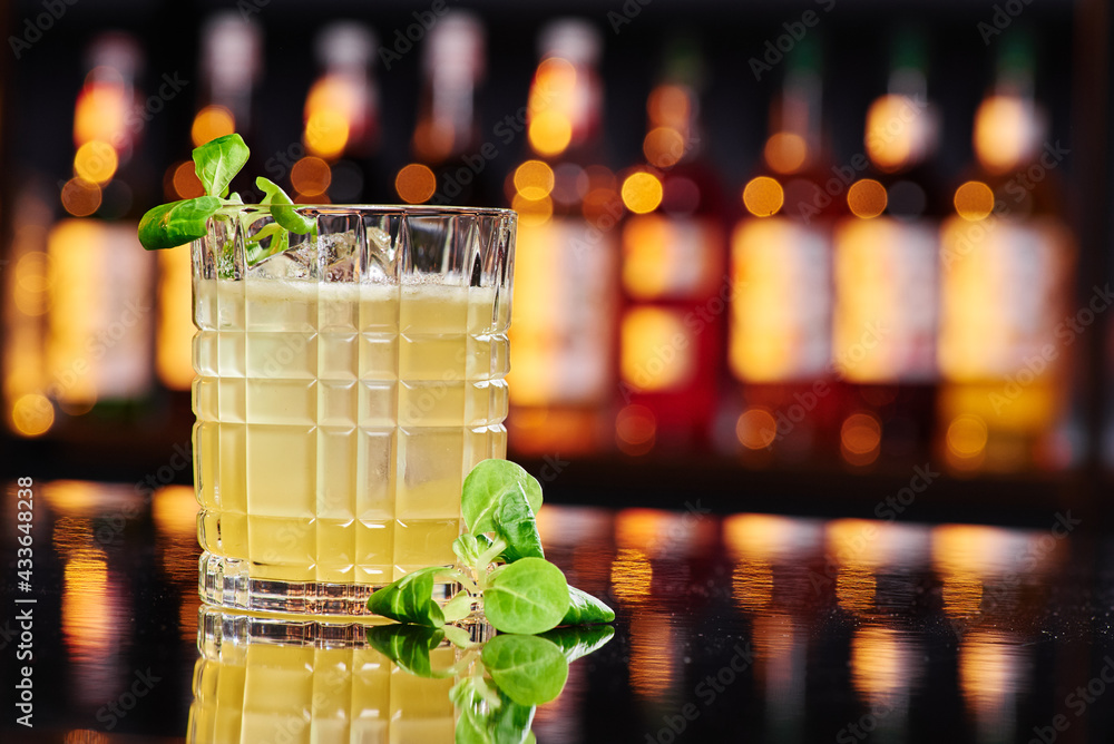 Beautiful yellow cocktail with ice, decorated pak choi cabbage in ...