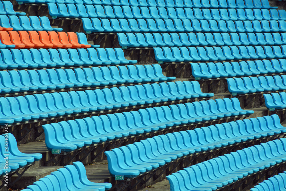 Blue and red seats in a curved pattern inside an abandoned sports ...