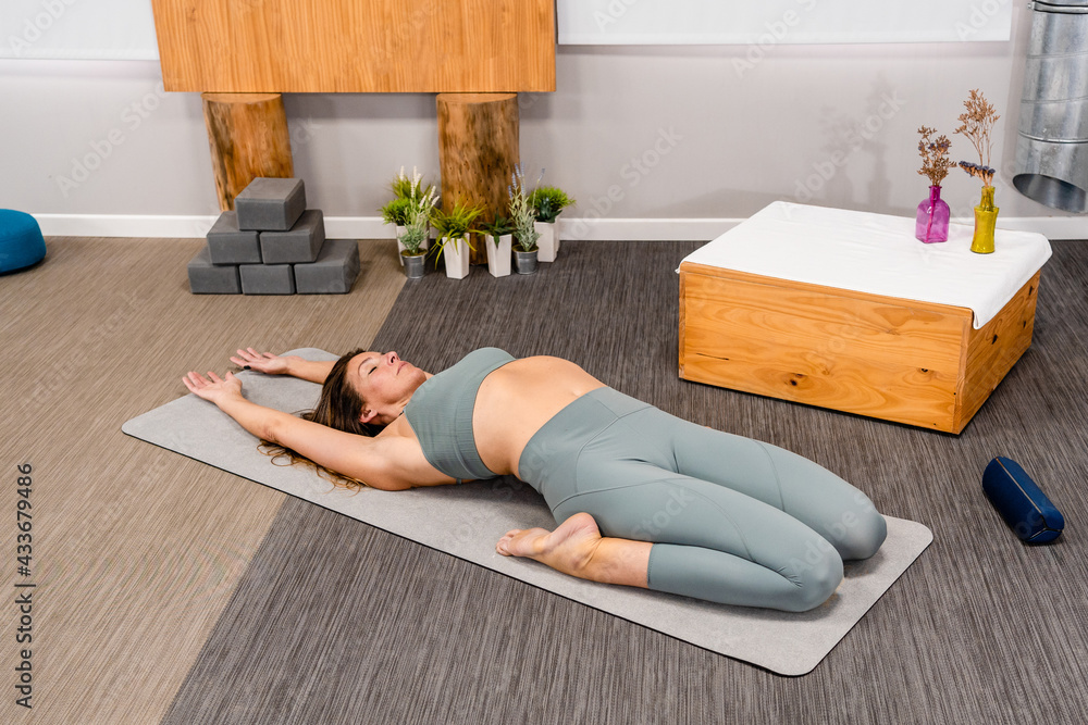 From above of flexible young female in activewear recreating in Utthita ...