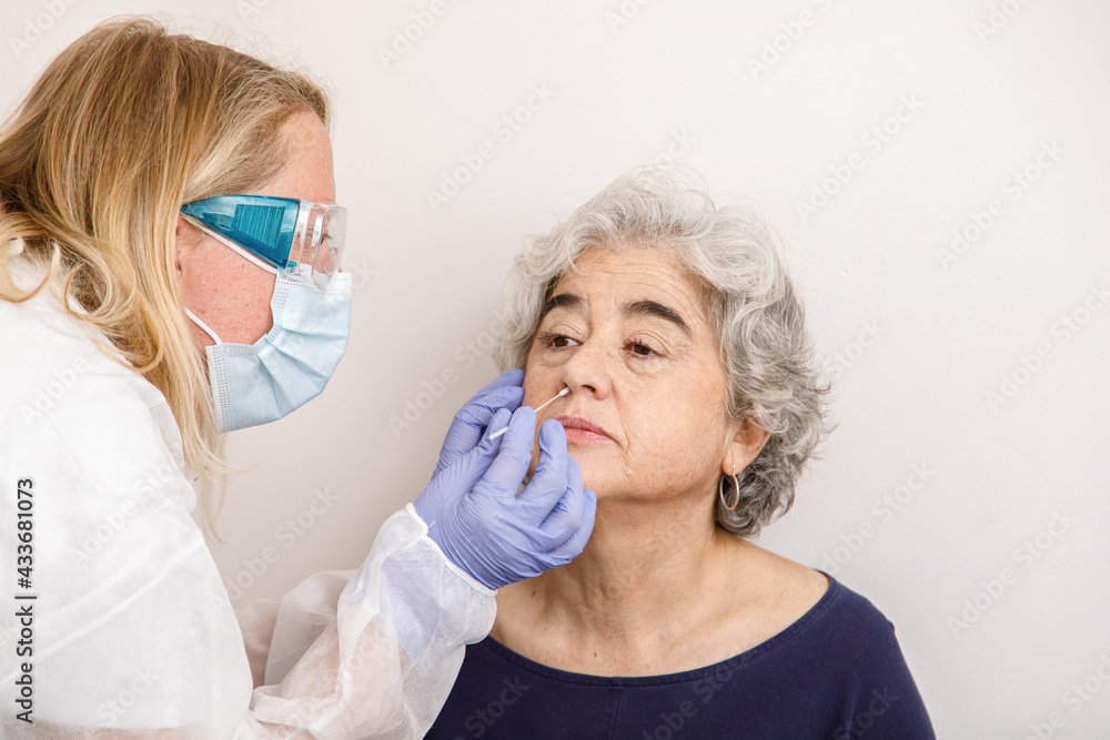Woman performing a nasal PCR test on a patient Stock Photo | Adobe Stock