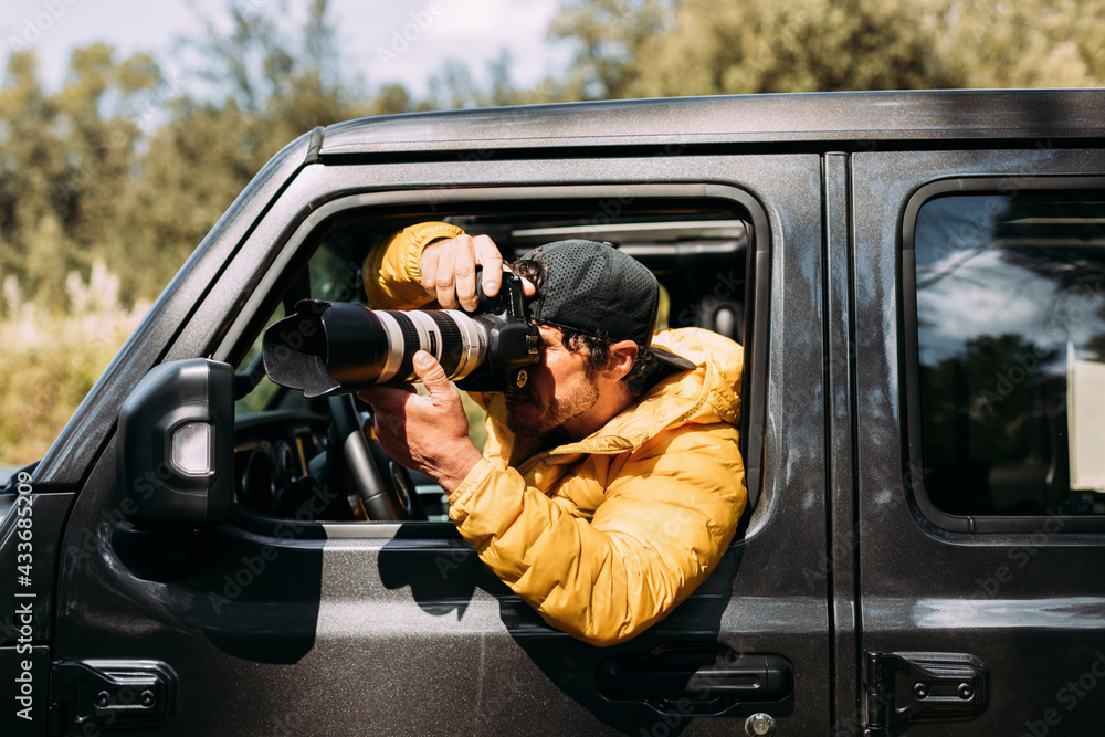 Side view of an adventurous photographer taking photos from inside his ...
