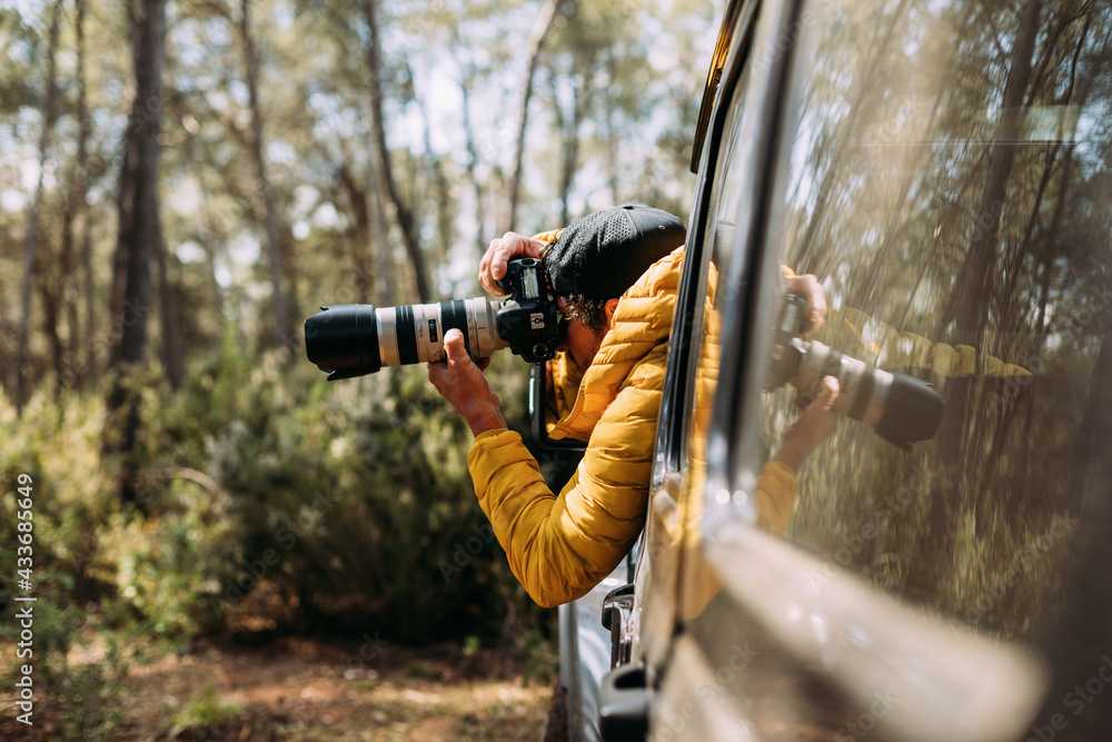 Side view of an adventurous photographer taking photos from inside his ...