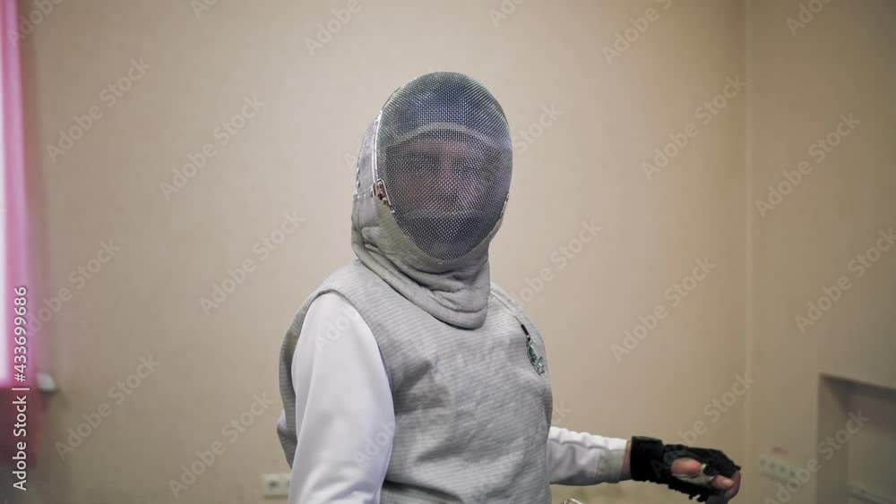 fencing. white fencing uniformed fencer, in fencing safety helmet, is ...