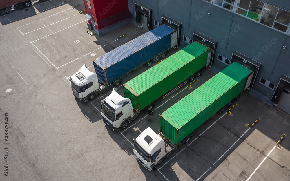 Foto de Three trucks loading in the logostics center do Stock | Adobe Stock