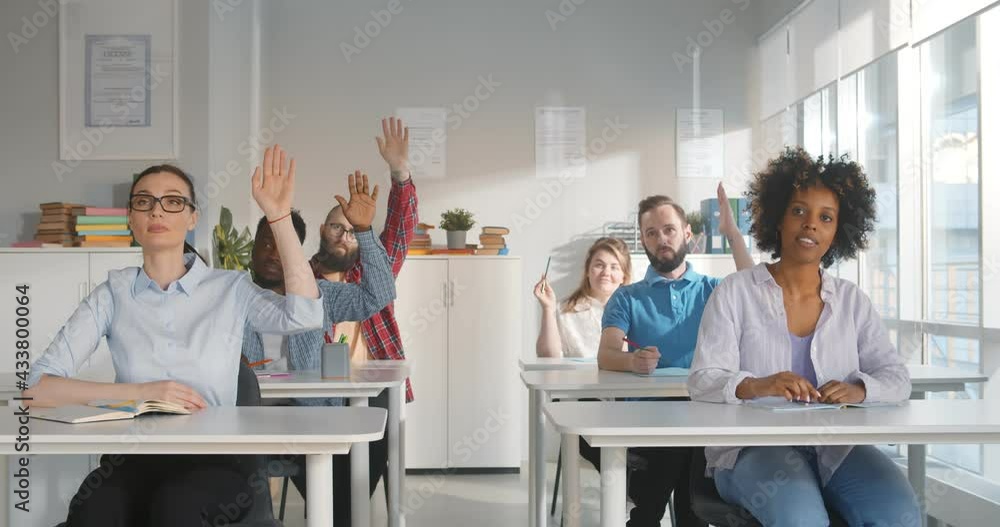 Adult education class students raising hands to ask questions. Stock ...