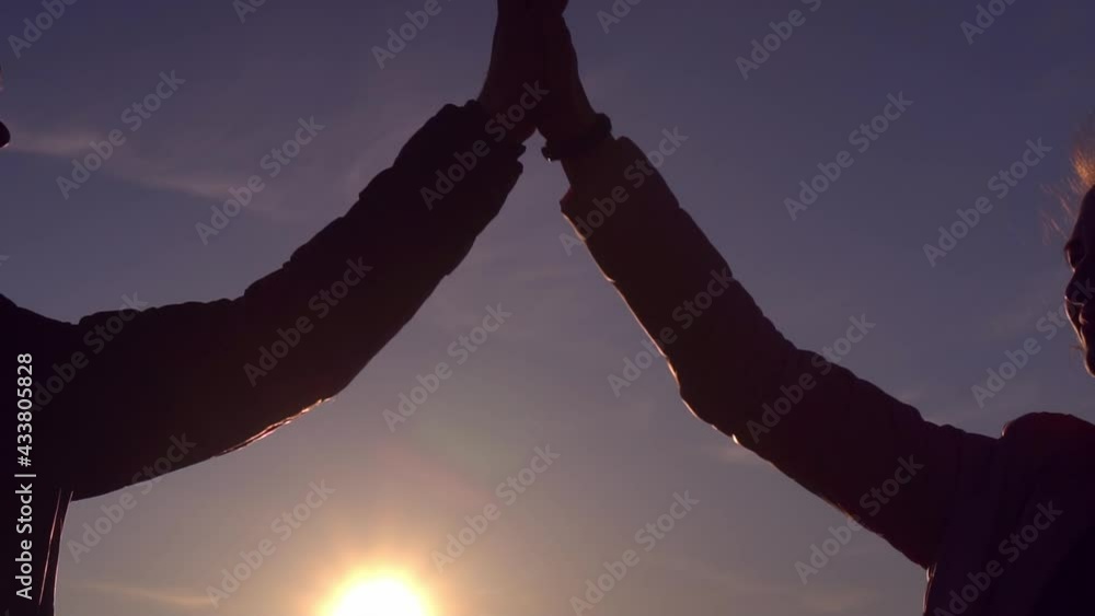 hands of young men of guy and girl giving high fives at sunset. Two ...