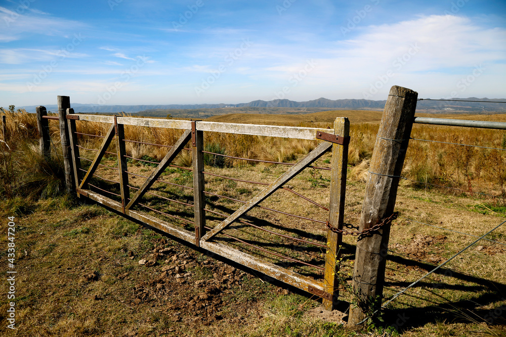 Country gate. Landscape of field and mountains. Nature. Blue sky with ...