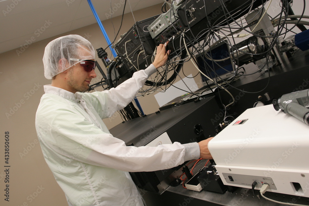 Scientist in a laser technology research laboratory working on a high ...