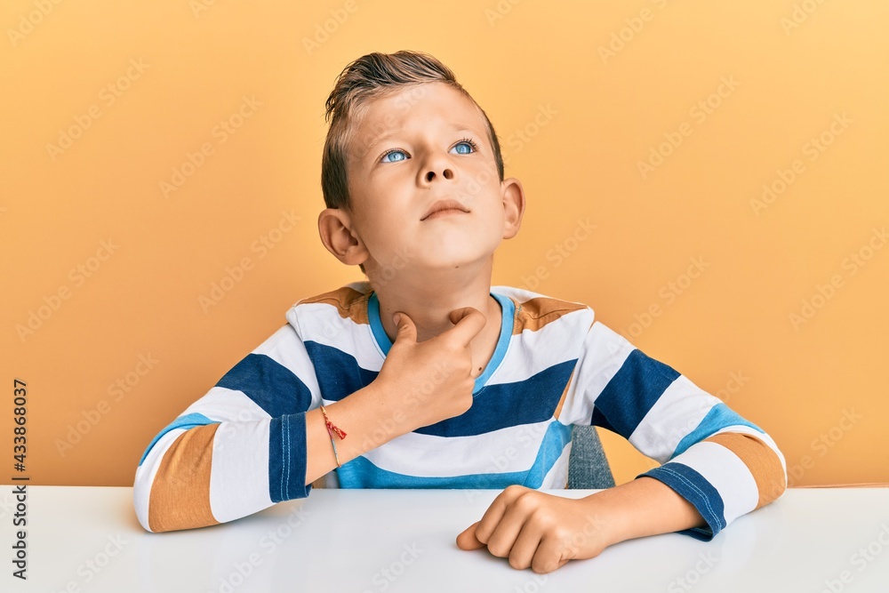 Adorable caucasian kid wearing casual clothes sitting on the table ...